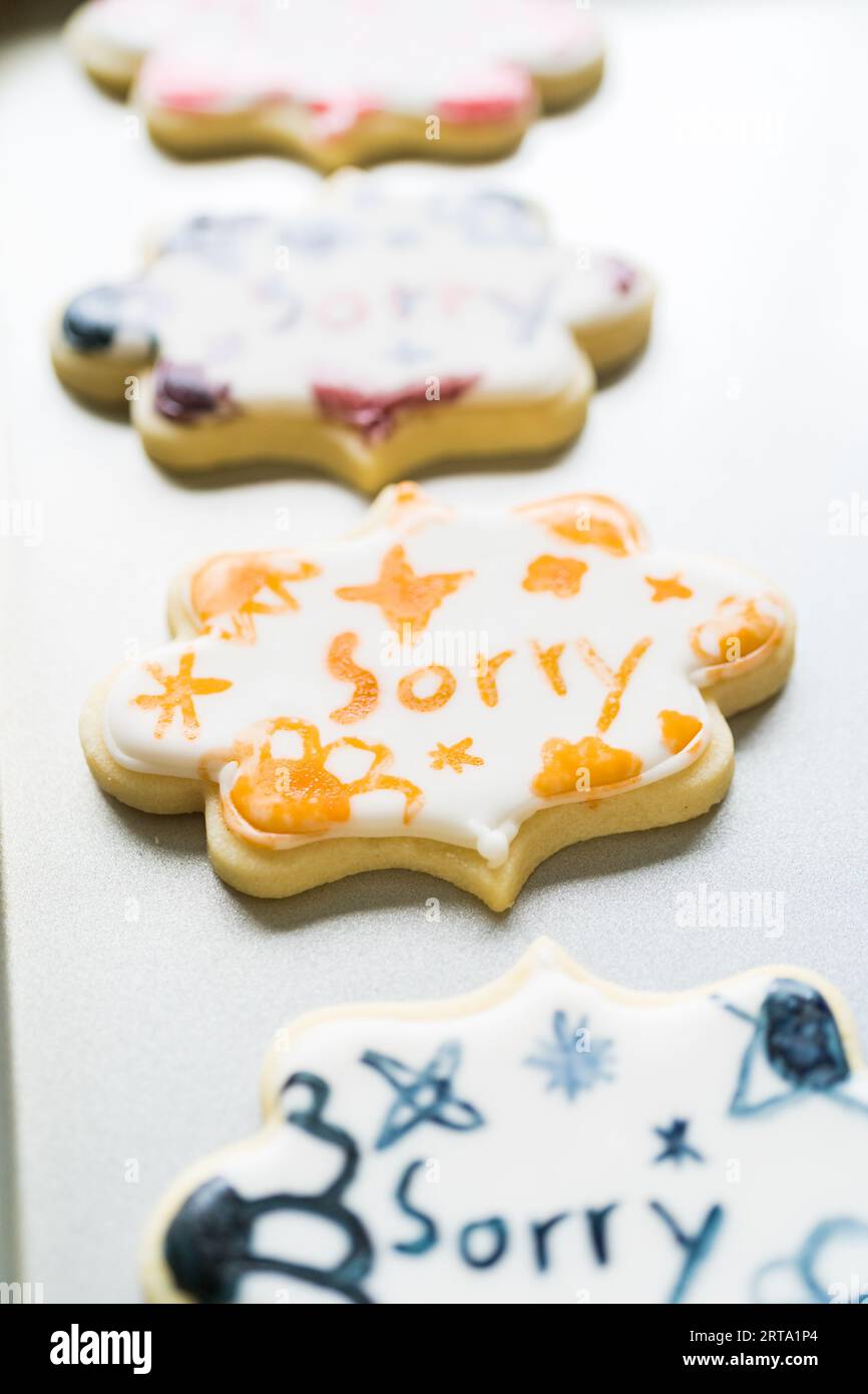 Little Girl Spells 'Sorry' on Iced Sugar Cookies Stock Photo - Alamy