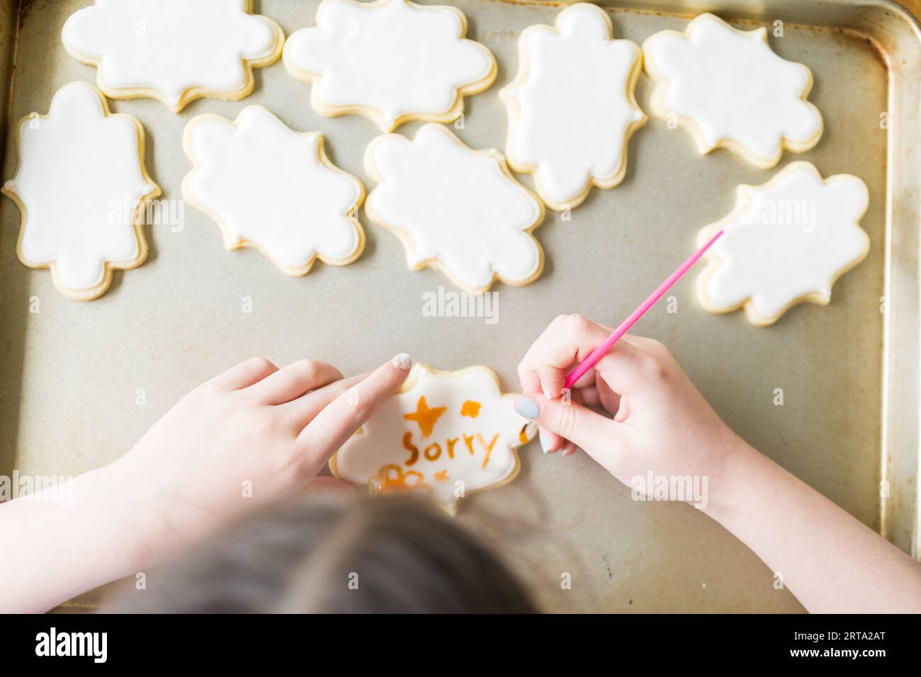 Little Girl Spells 'Sorry' on Iced Sugar Cookies Stock Photo - Alamy