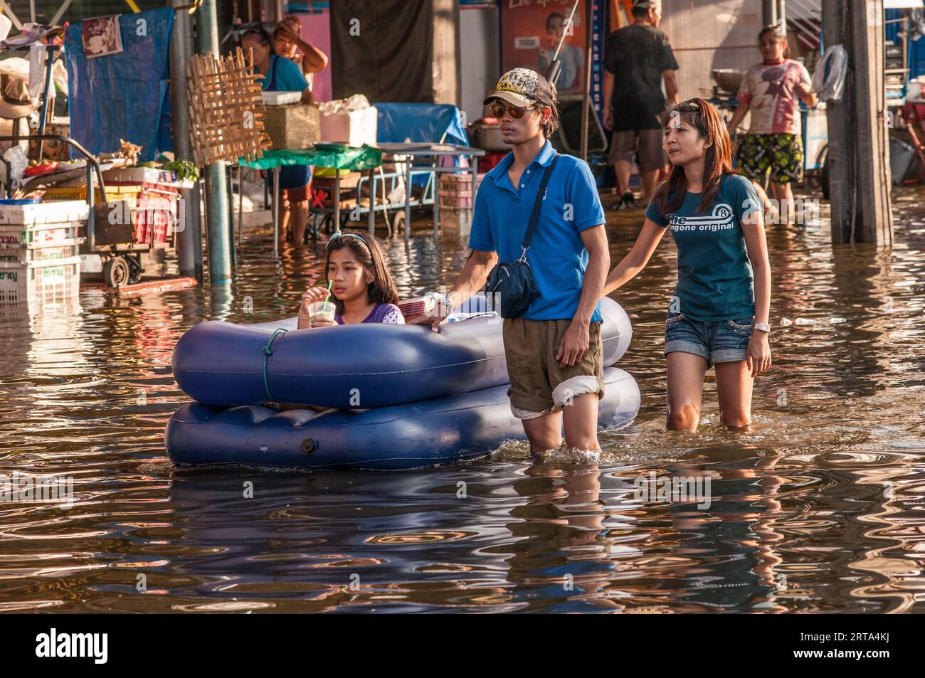 climate refugees, a father, mother & daughter, wade through floodwaters ...
