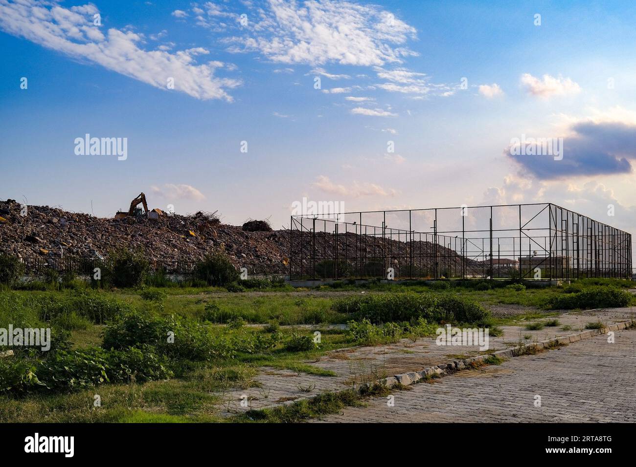 A sports field is seen next to the piles of rubble. Mileyha Wetland is ...