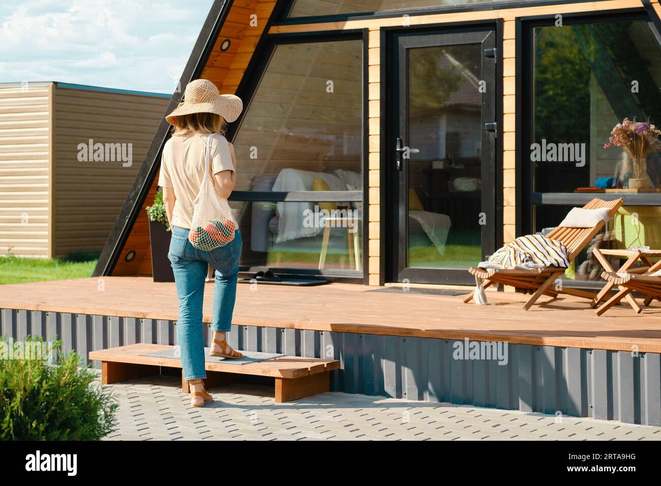 Adult woman returns from the farmer market to her wooden cabin Stock ...