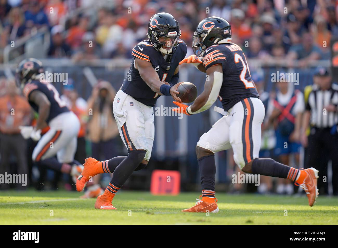 Chicago Bears quarterback Justin Fields (1) hands off to running back ...