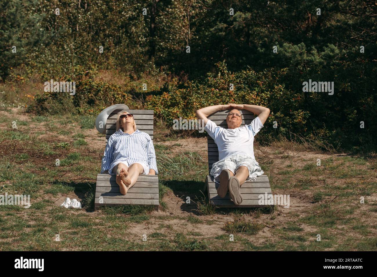 Old couple lying on sunbeds hi-res stock photography and images - Alamy