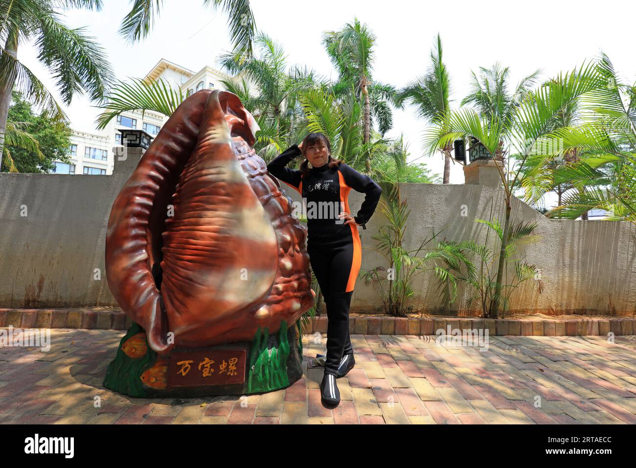 Sanya, China - April 1, 2019: a lady play in front of huge conch ...