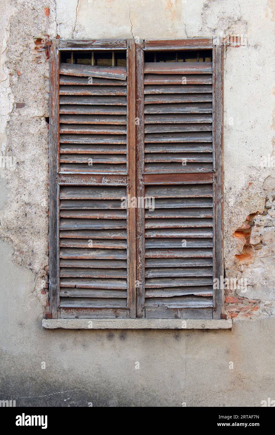 old window with shutters, an ancient wall facade with slightly broken ...