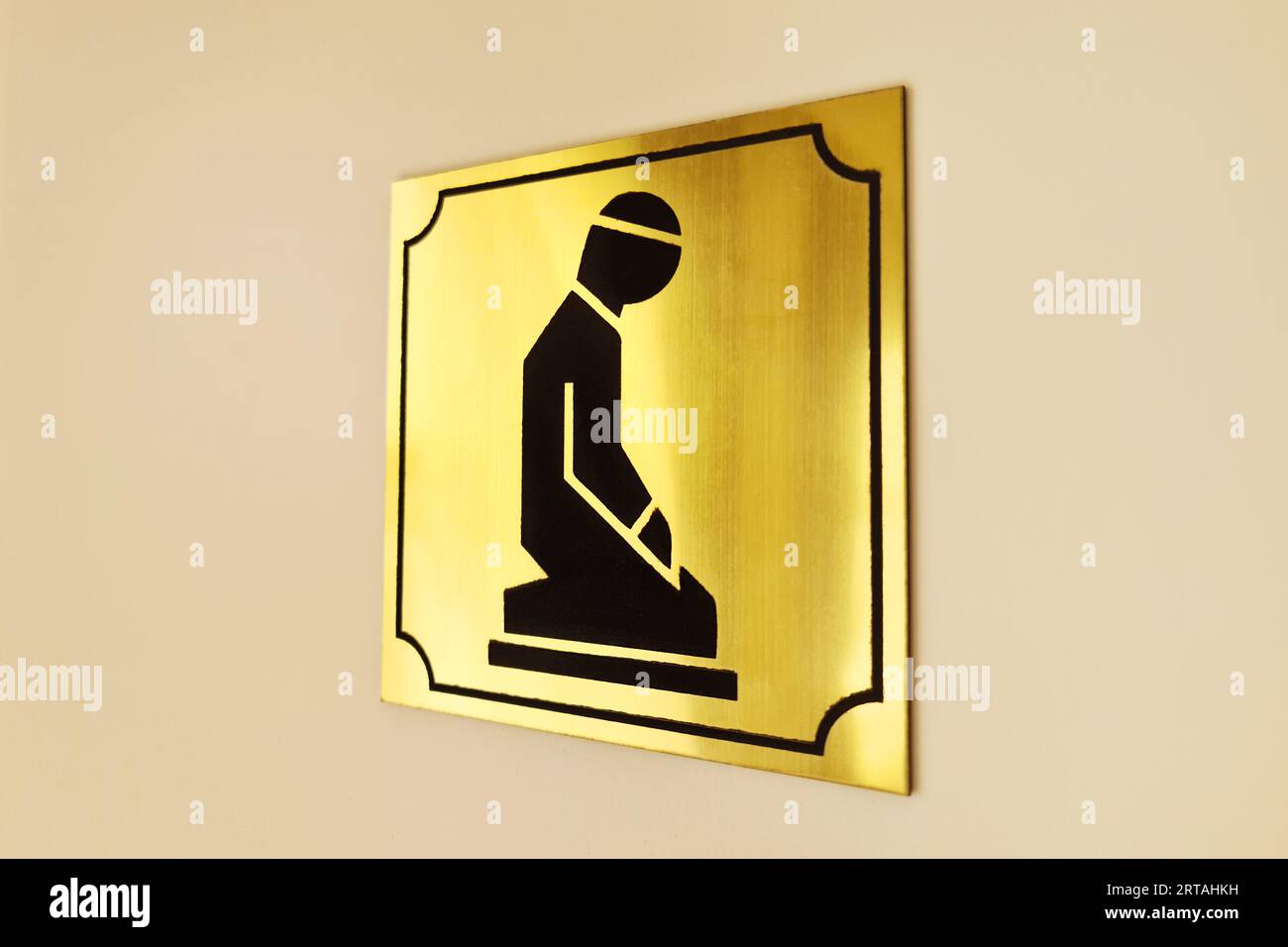 A plate with a drawing of a praying person on the door of a prayer room ...
