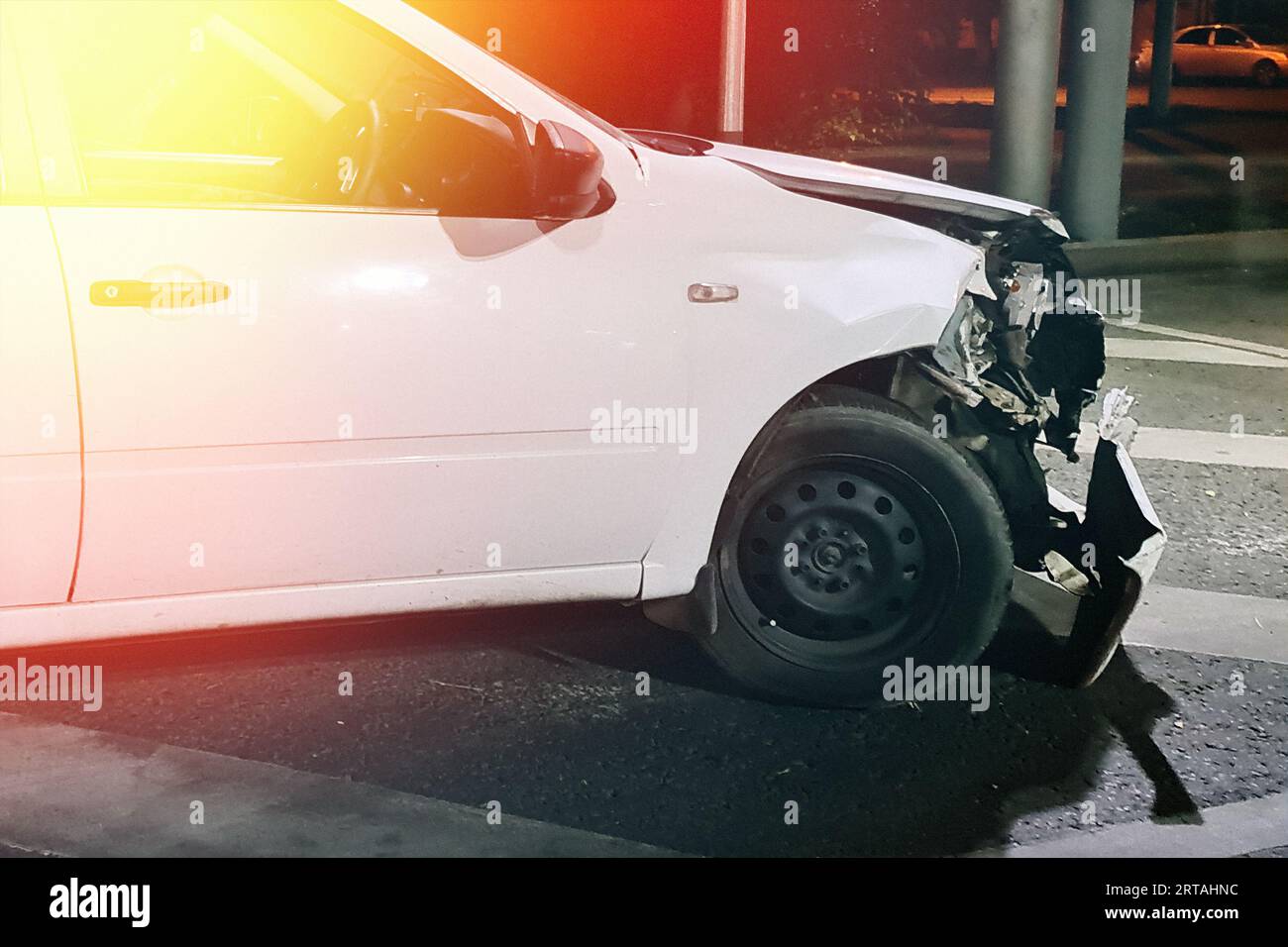 Broken car after a frontal collision, side view of a night accident ...