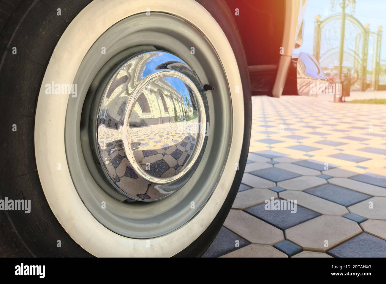 Detail of a retro car - a wheel with a white border and a chrome cap ...