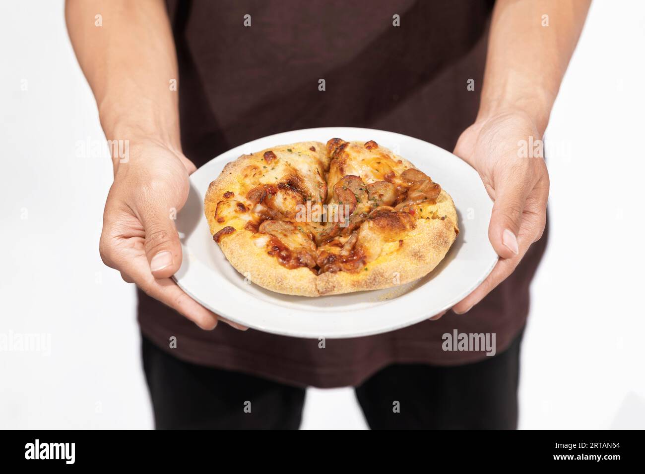 A human hand holding pizza on a plate with a white background Stock ...