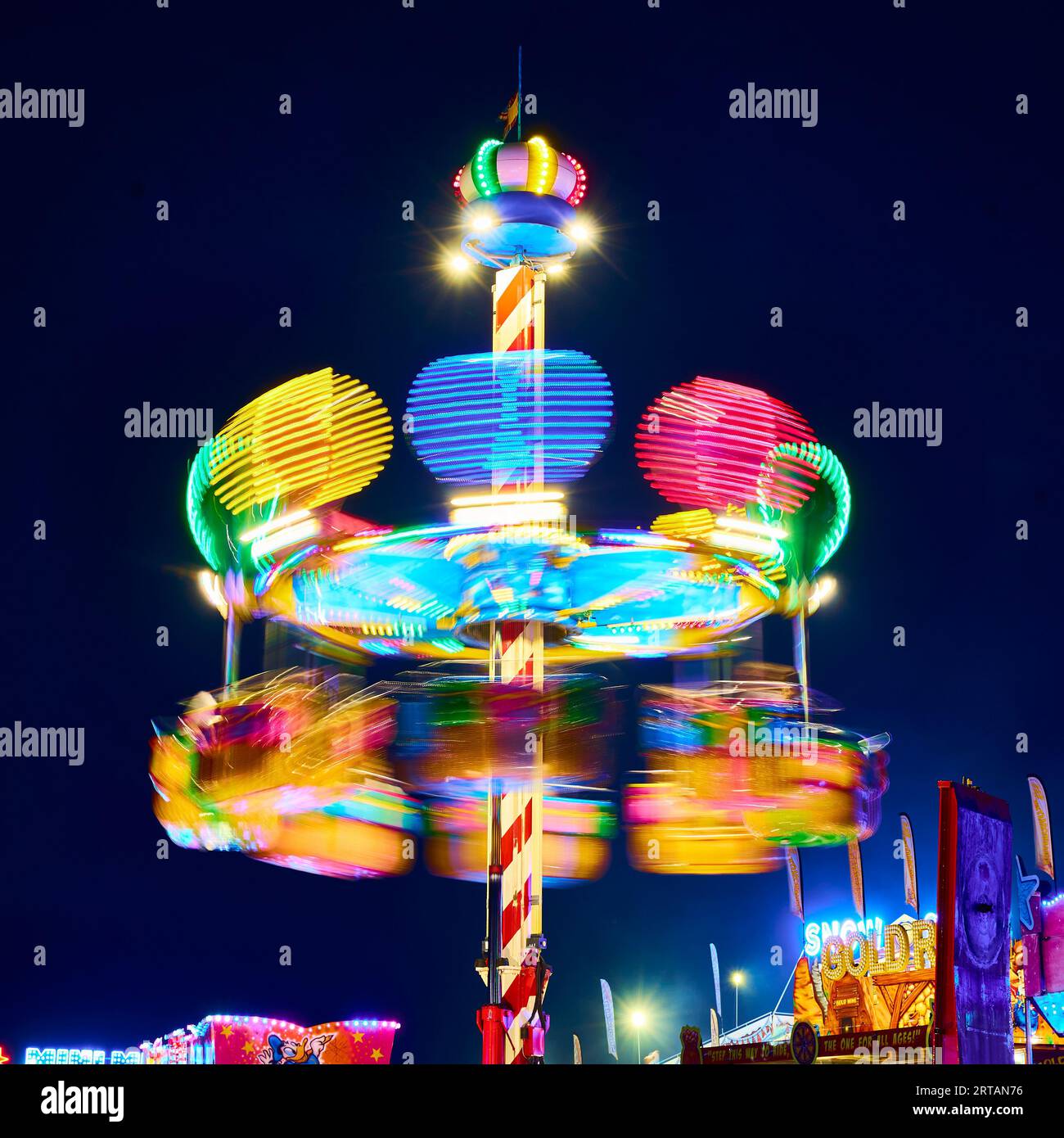 Hot air balloon vertical roundabout on funfair at night Stock Photo - Alamy