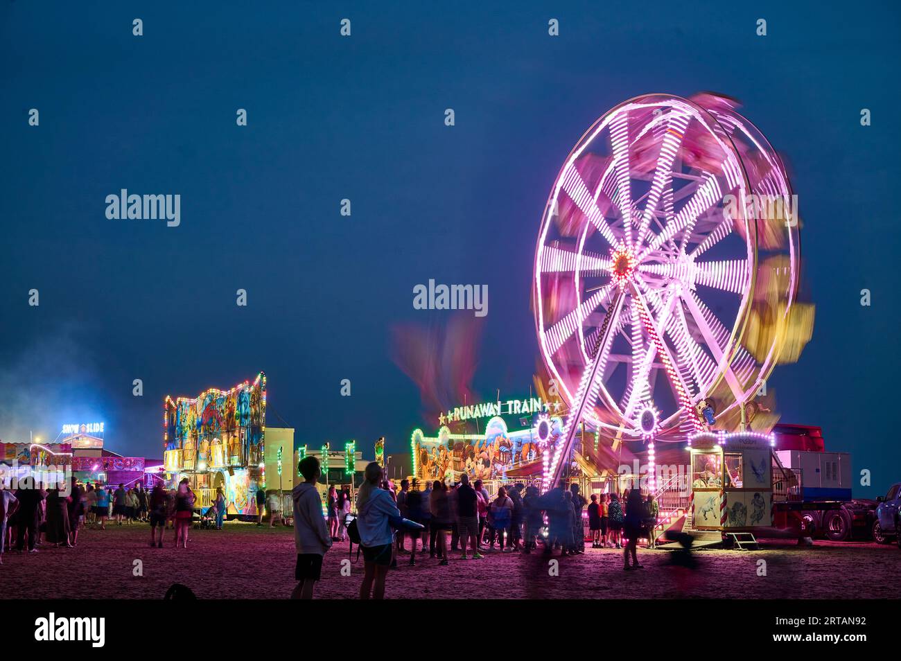 Funfair At Night On Beach In Summer Runaway Train And Ferris Wheel