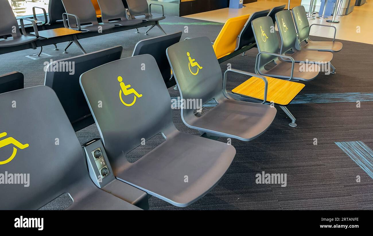 Seats for disabled people in the waiting area at the airport. Departure ...