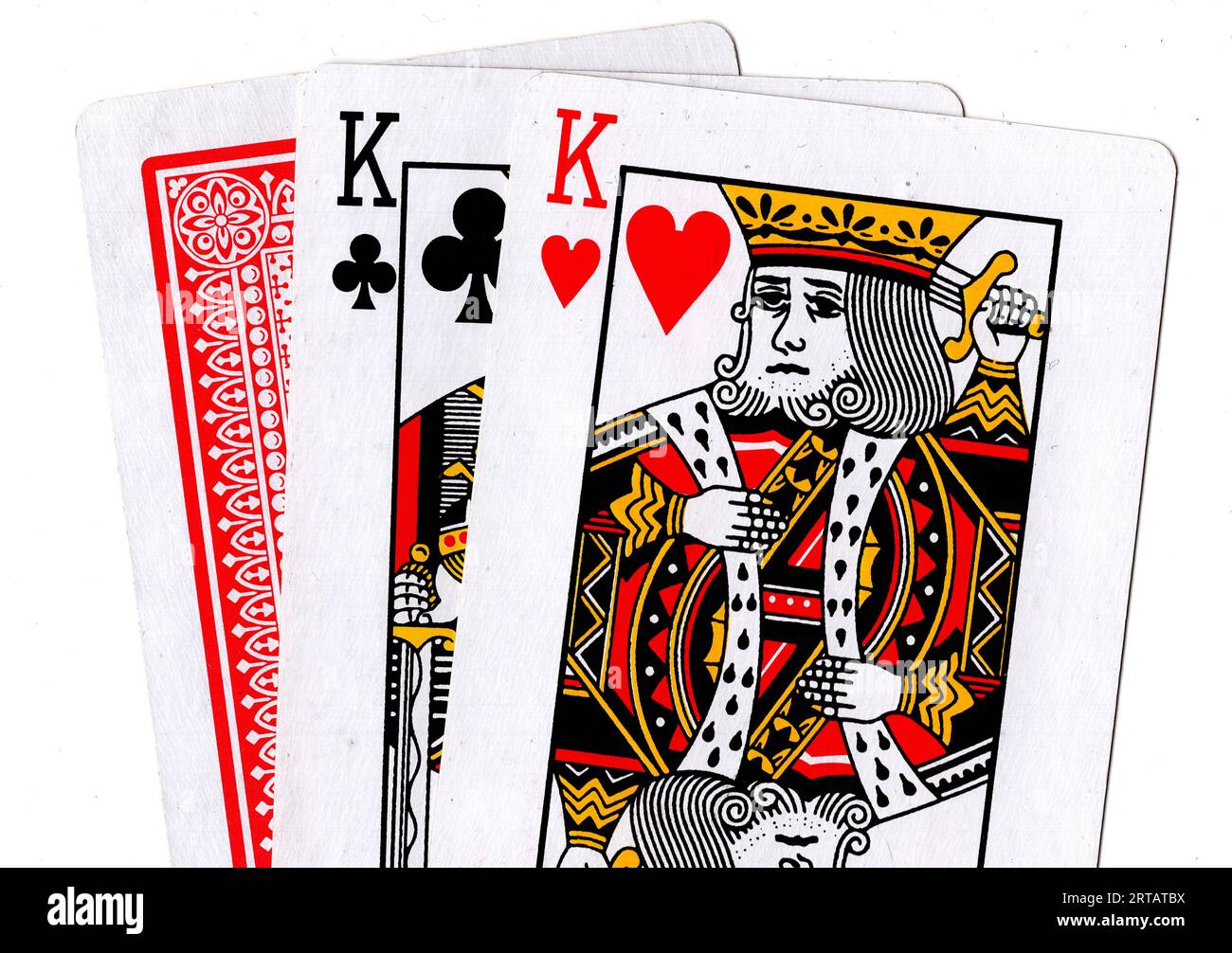 A hand of three playing cards revealing two kings on a white background ...