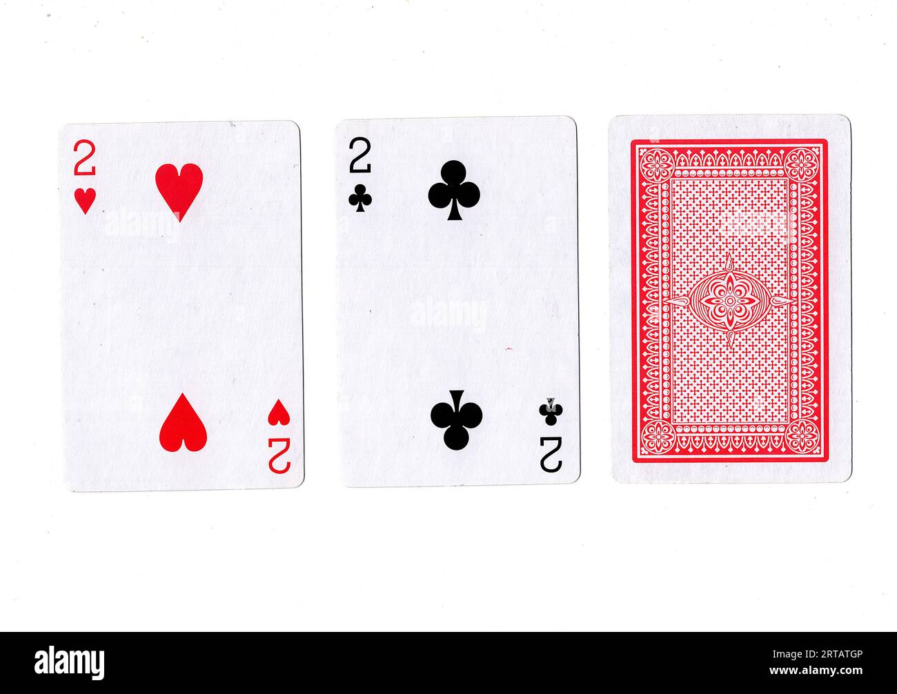 A hand of three playing cards revealing two twos on a white background ...