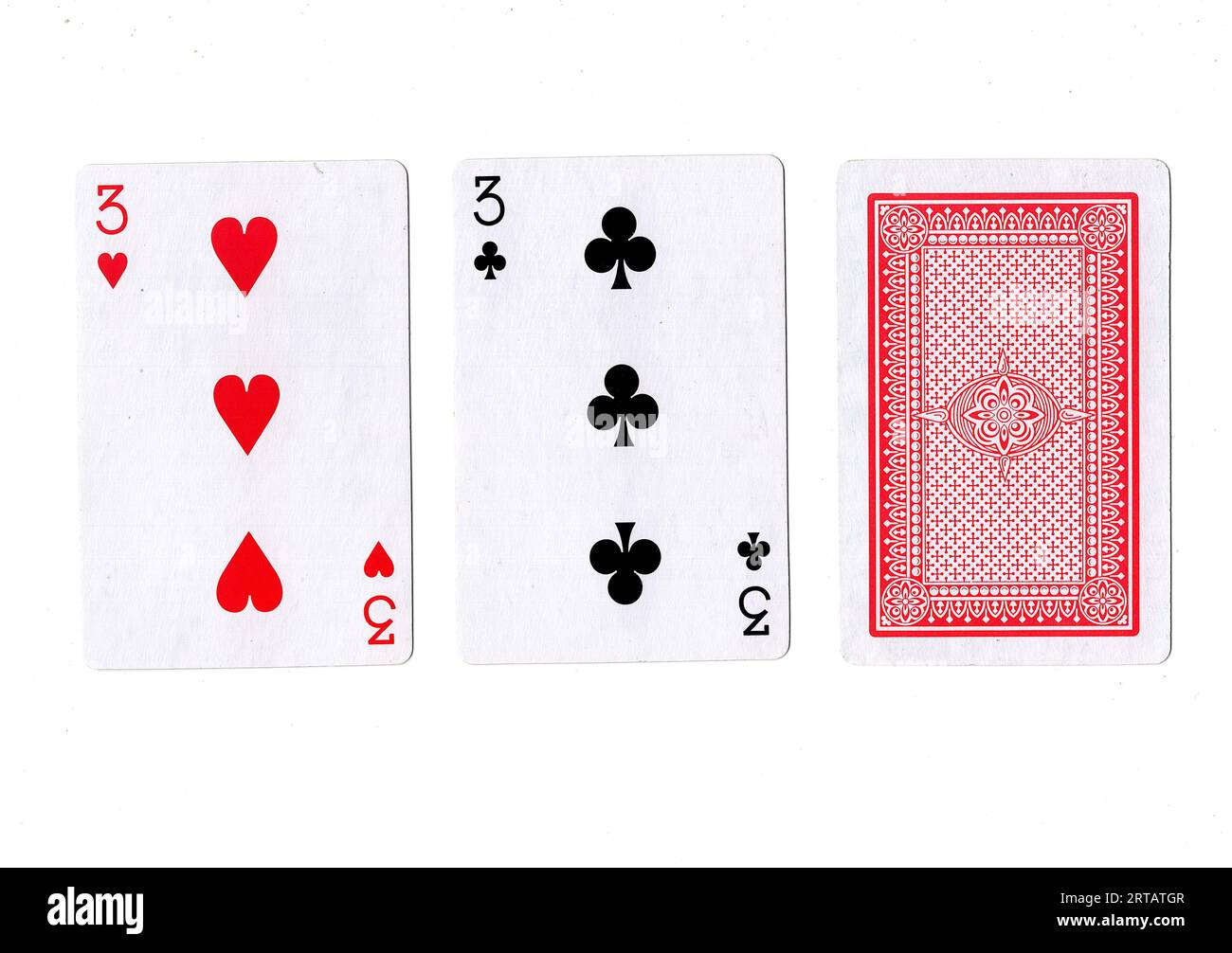A hand of three playing cards revealing two threes on a white ...