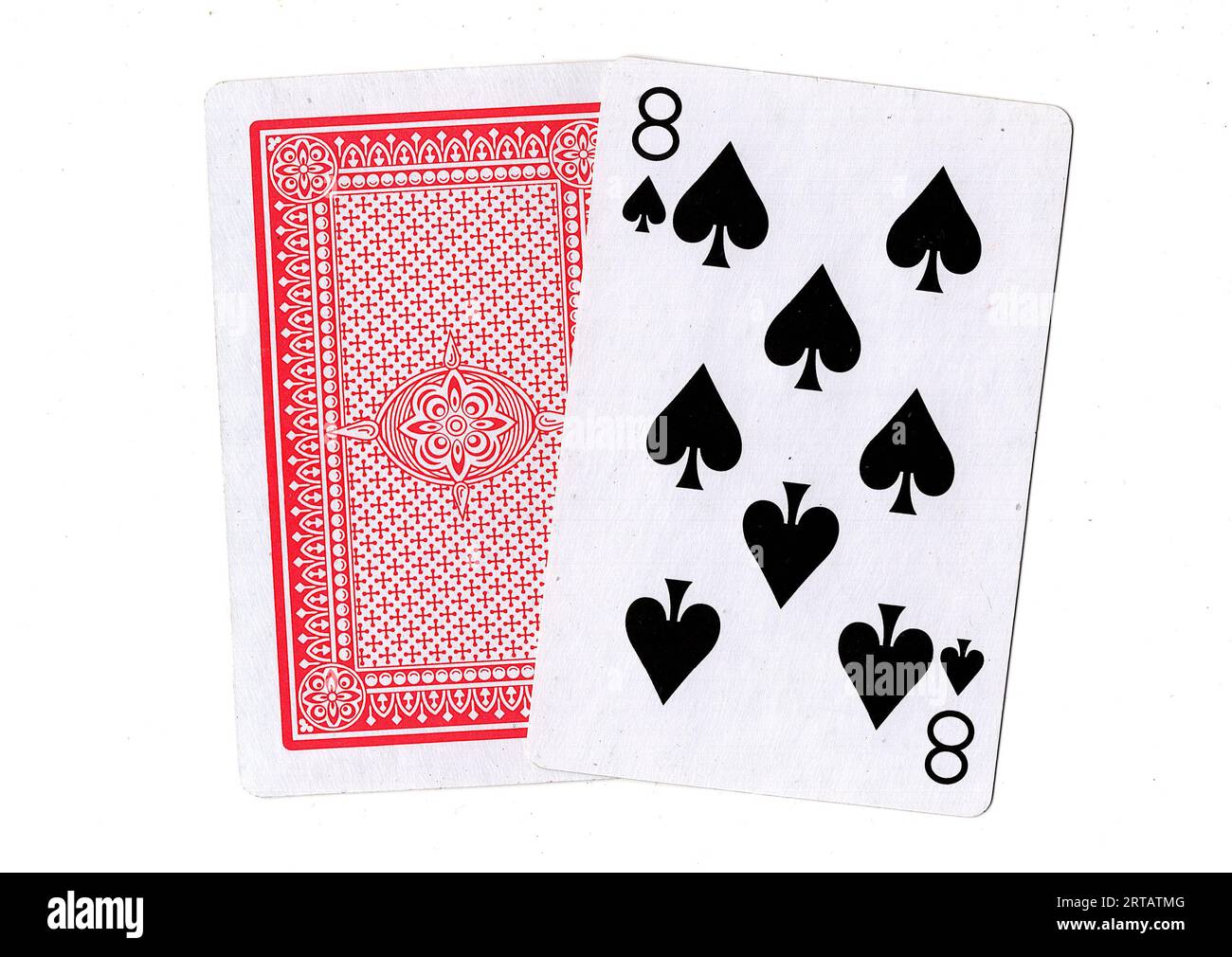 A pair of vintage playing cards revealing an eight of spades on a white ...