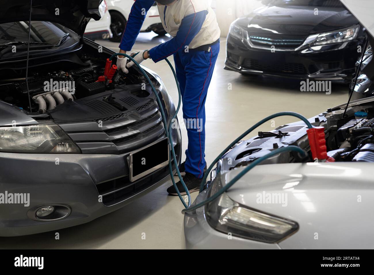 Close-up of a mechanic hand charging a car battery Car repair with ...