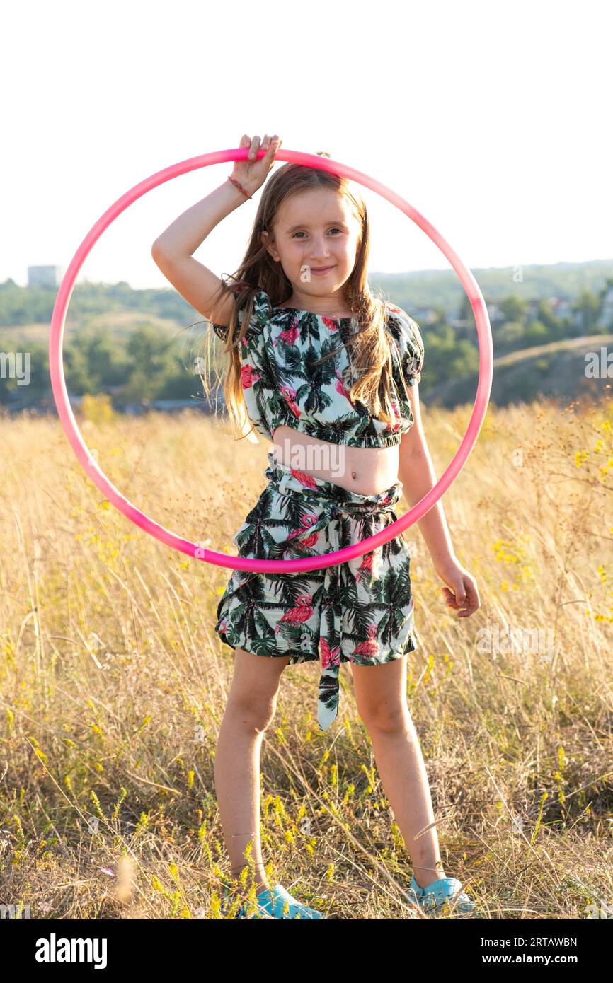 Little girl with a gymnastic hoop in nature in the summer Stock Photo ...