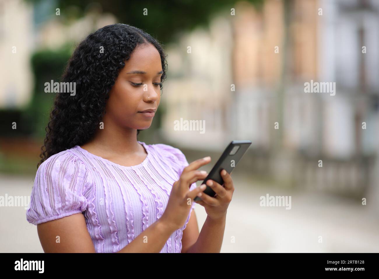 Mobile looking woman walking typing hi-res stock photography and images ...