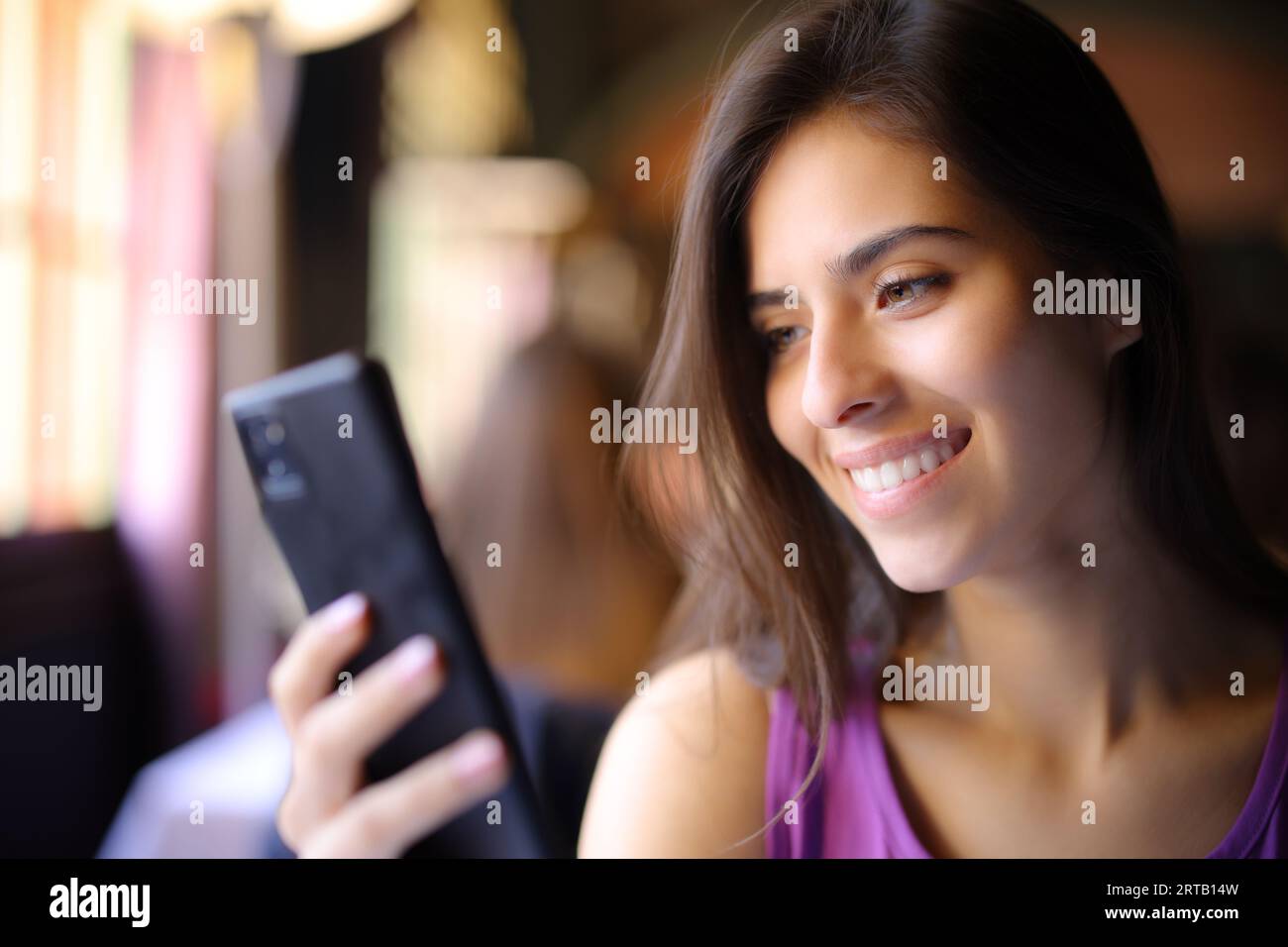 Happy restaurant customer using cell phone and smiling Stock Photo - Alamy