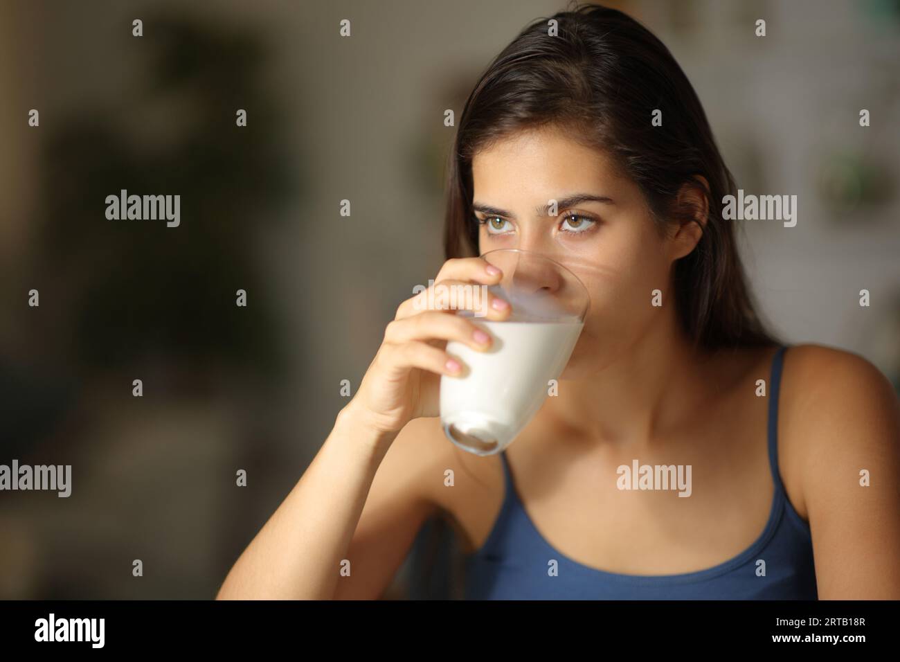 Serious woman drinking milk in the night at home Stock Photo - Alamy