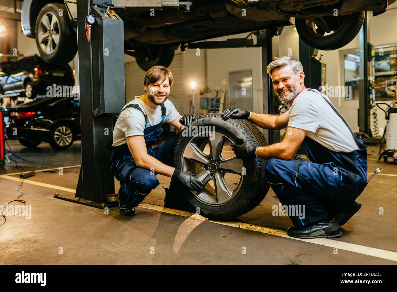 Caucasian male mechanic technician and his father repairing changing ...