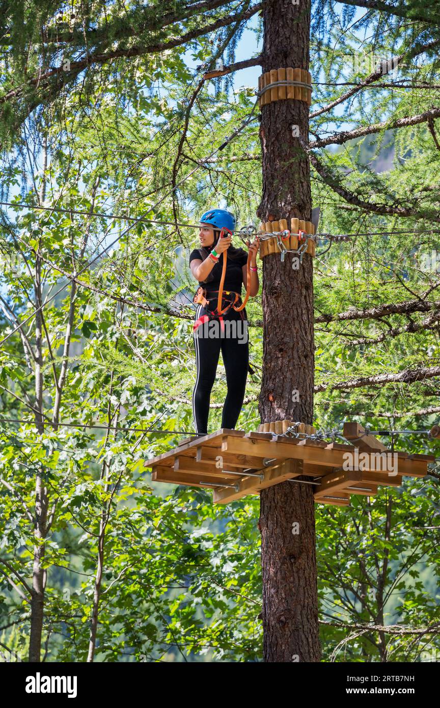 Low angle of teenage girl in helmet looking away while standing on ...