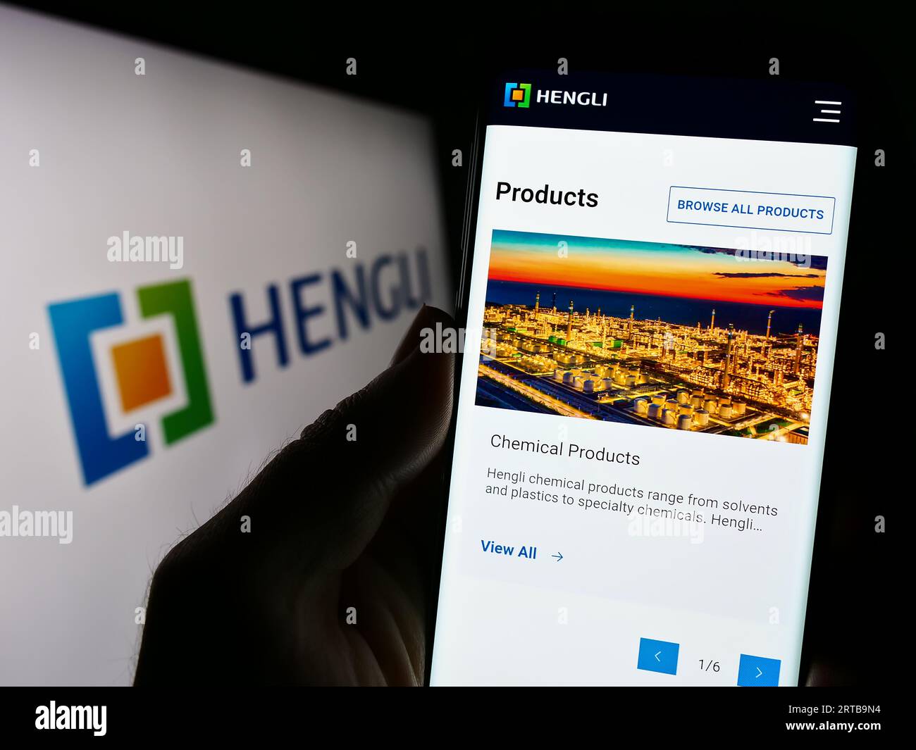 Person holding cellphone with webpage of Chinese petrochemical company Hengli Group on screen in ...