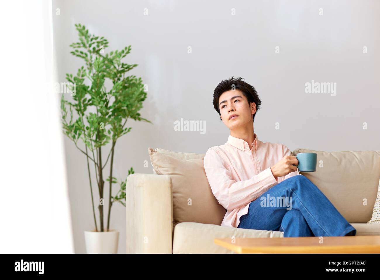 Japanese man relaxing at home Stock Photo - Alamy