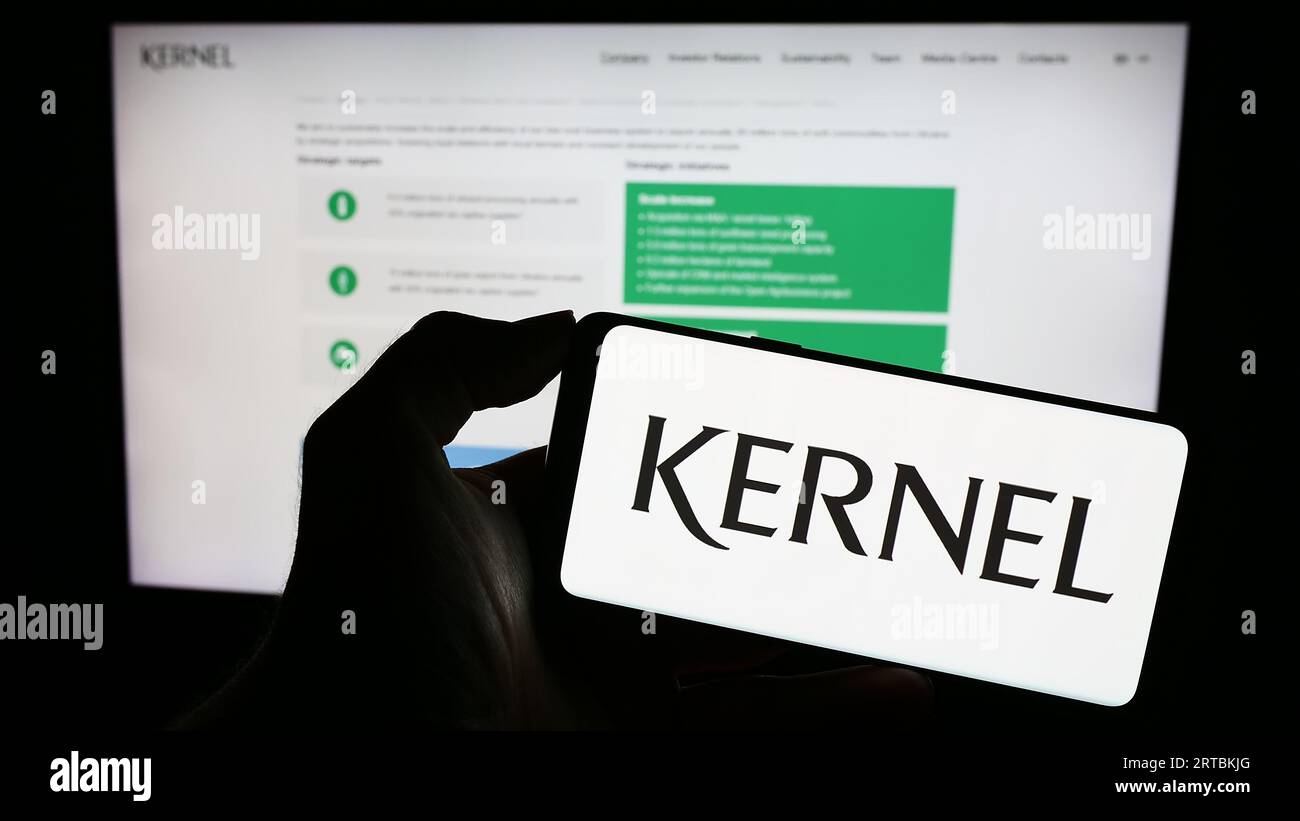 Person holding cellphone with logo of Ukrainian company Kernel Holding S.A. on screen in front ...