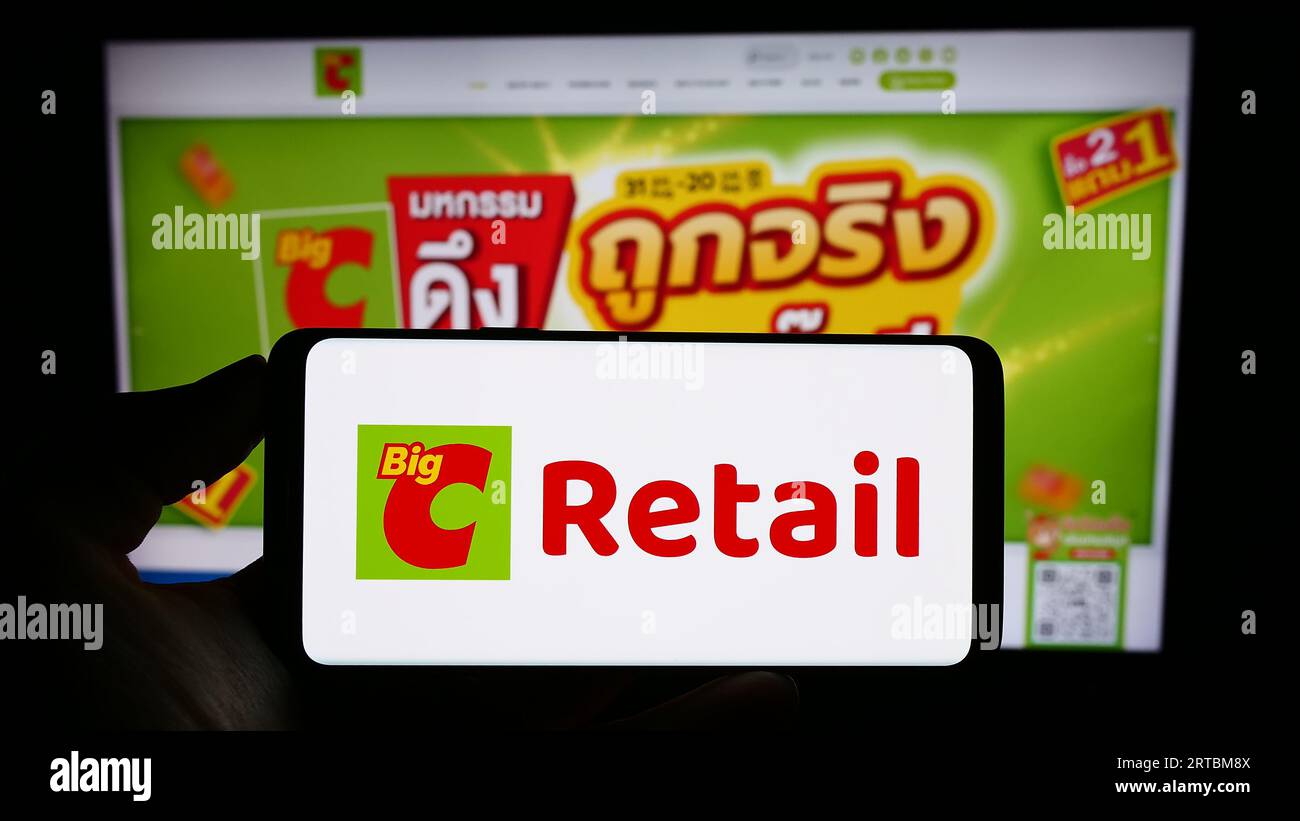 Person holding mobile phone with logo of company Big C Retail Corporation PCL (BRC) on screen in ...