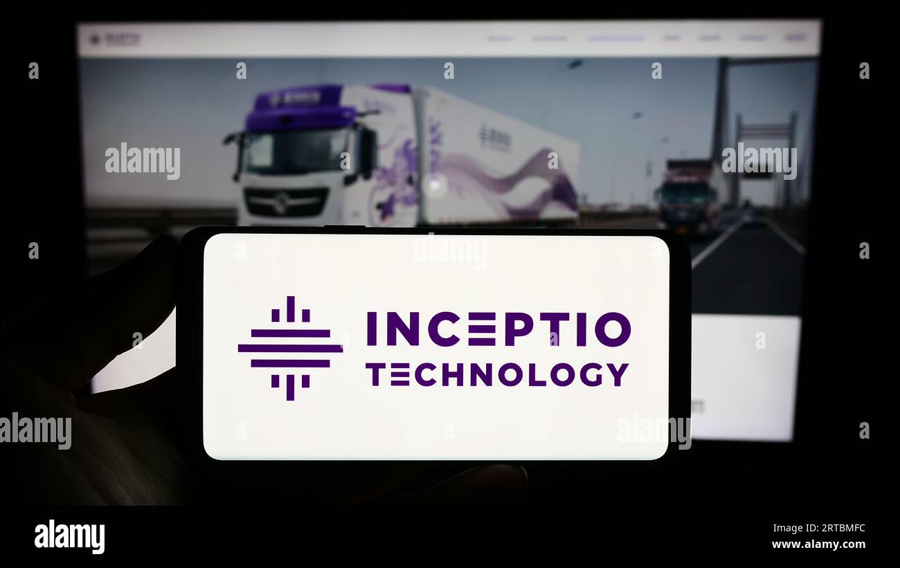 Person holding smartphone with logo of autonomous vehicle company ...