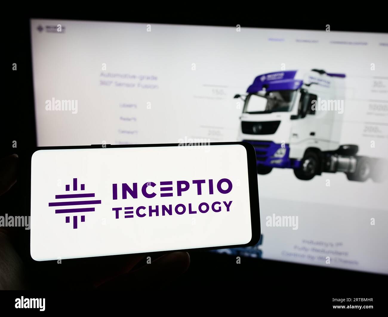 Person holding cellphone with logo of autonomous vehicle company ...