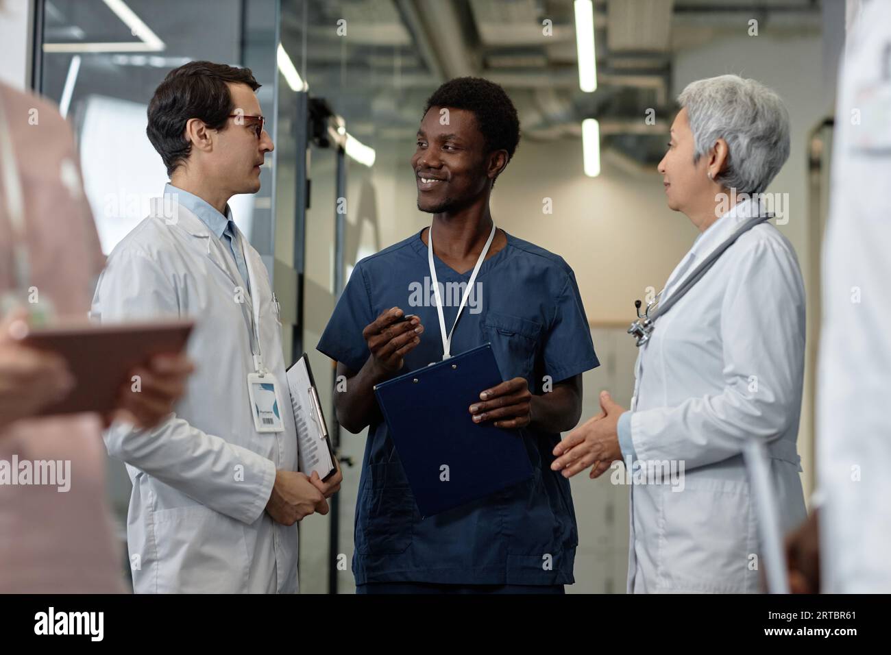 Happy young African American male assistant with medical document ...