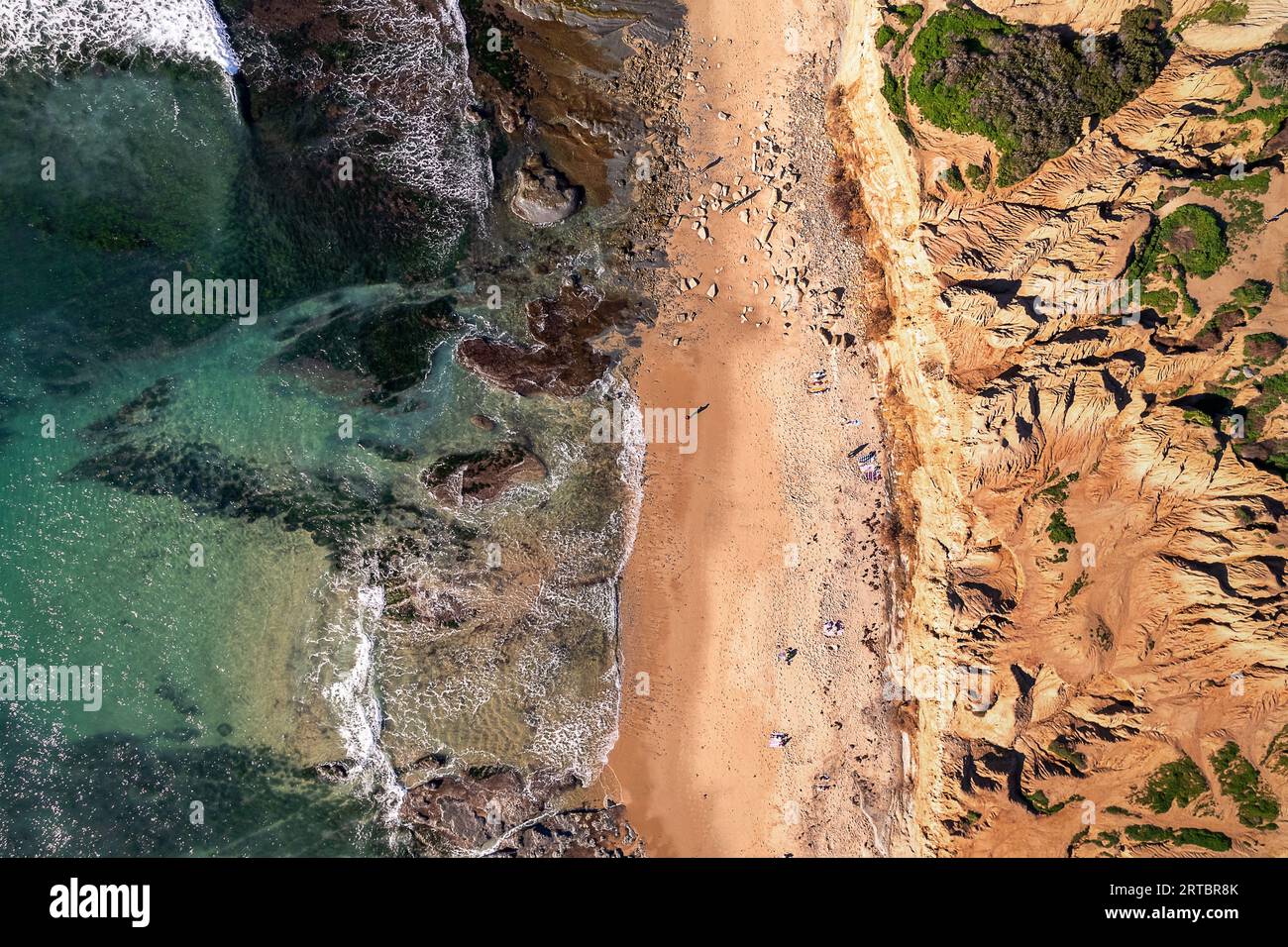 Aerial view of sunny rock and clear, bright blue, sparkling Pacific ...