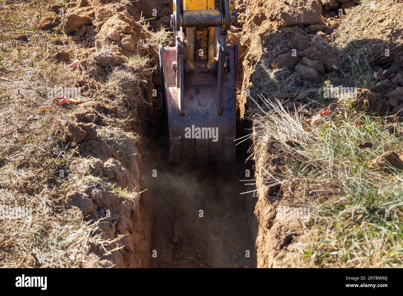 Small excavator digging a trench ditch for a building foundation Stock ...