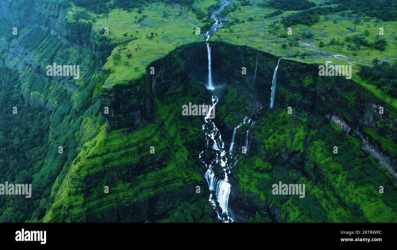 A majestic waterfall cascades through a picturesque valley surrounded ...