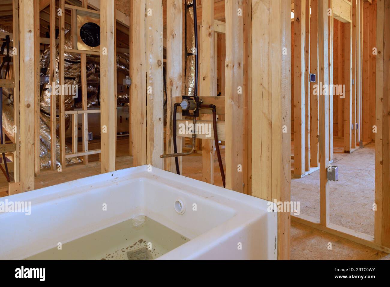 Between beams frame, newly installed acrylic bathtub in home under ...