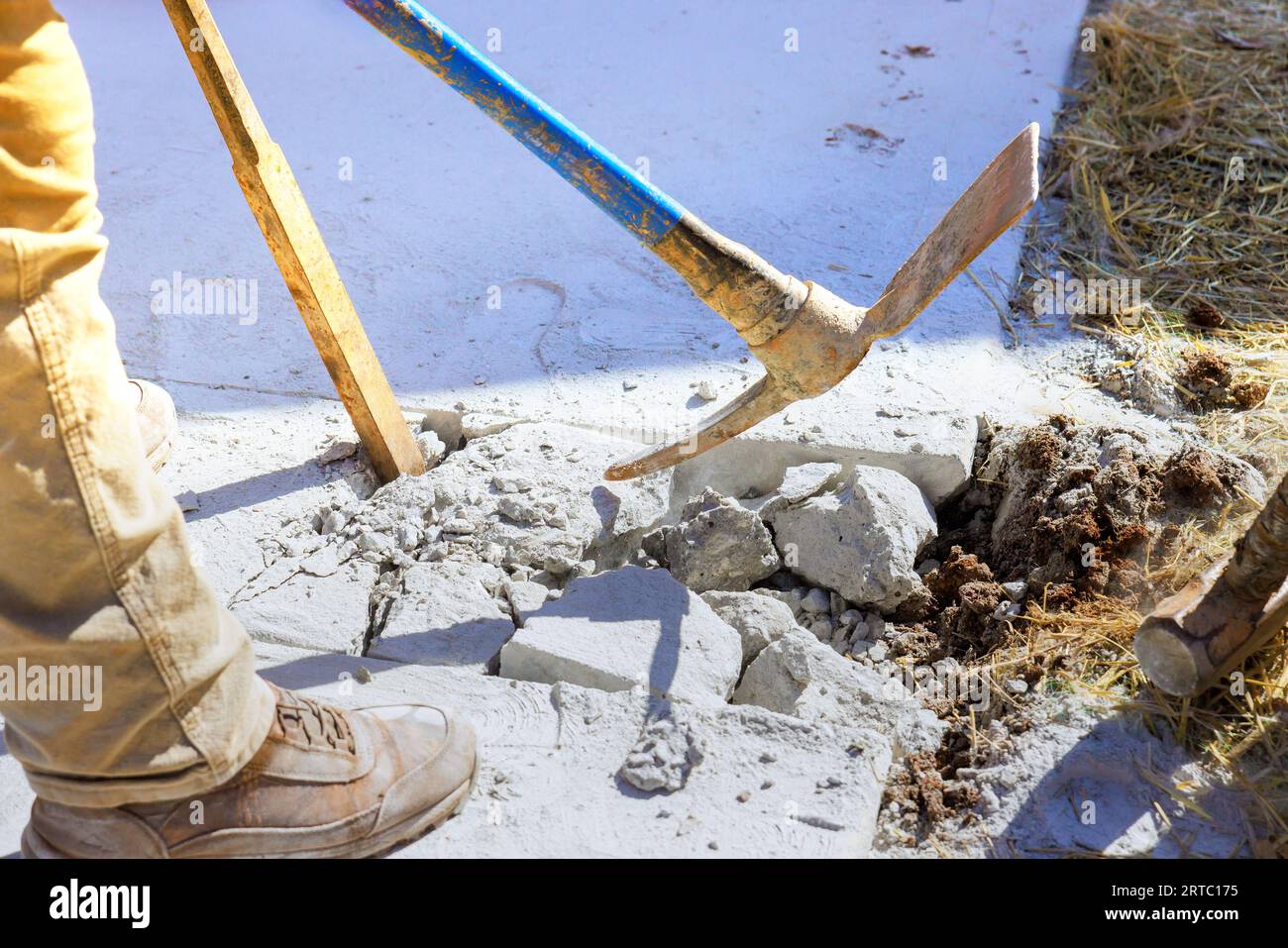 Pickaxe wielding worker smashes concrete old driveway on construction ...