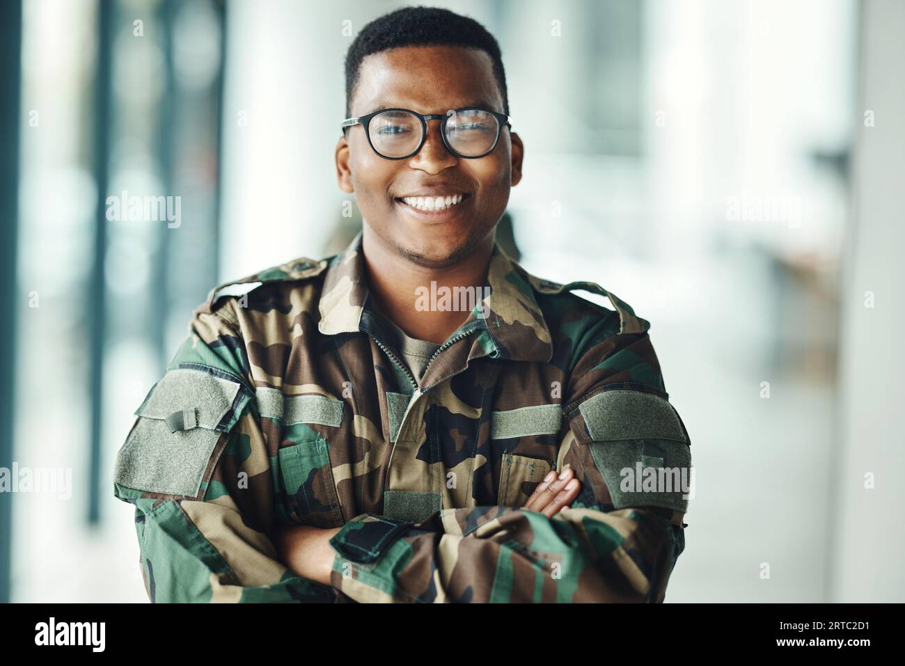 Portrait of soldier with smile, confidence and pride at army building, arms crossed and happy ...