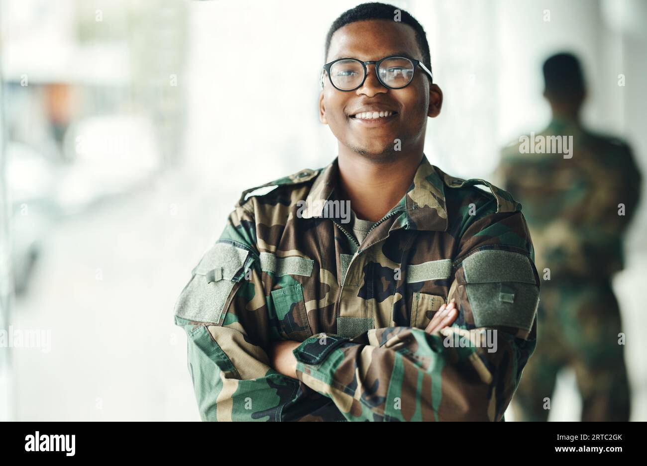 Confident soldier portrait, smile and arms crossed in army building ...