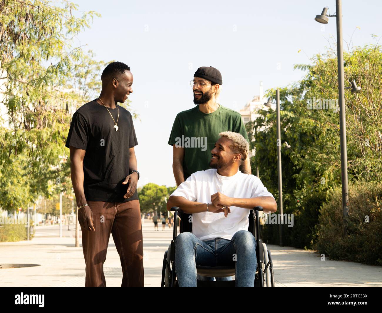 Group of young diverse male friends walking through a city, one of them ...