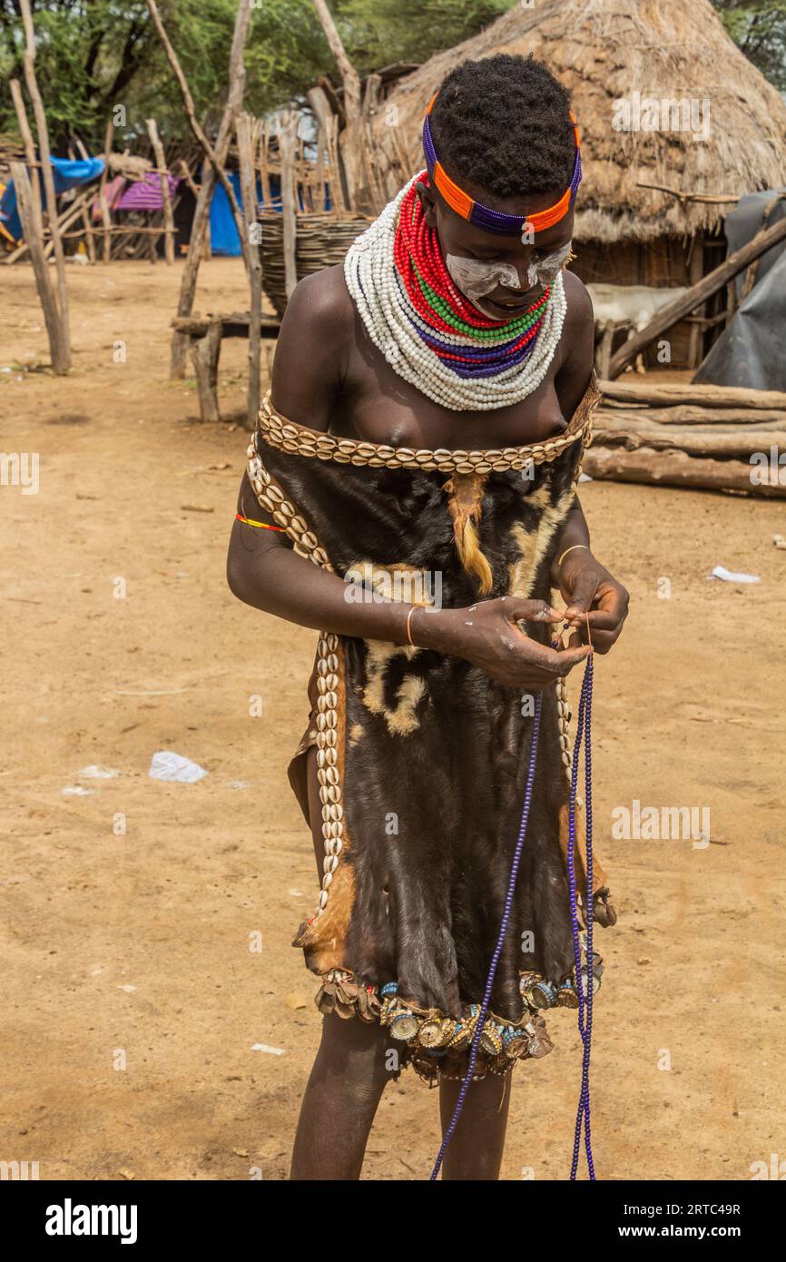 KORCHO, ETHIOPIA - FEBRUARY 4, 2020: Karo tribal girl making bead ...