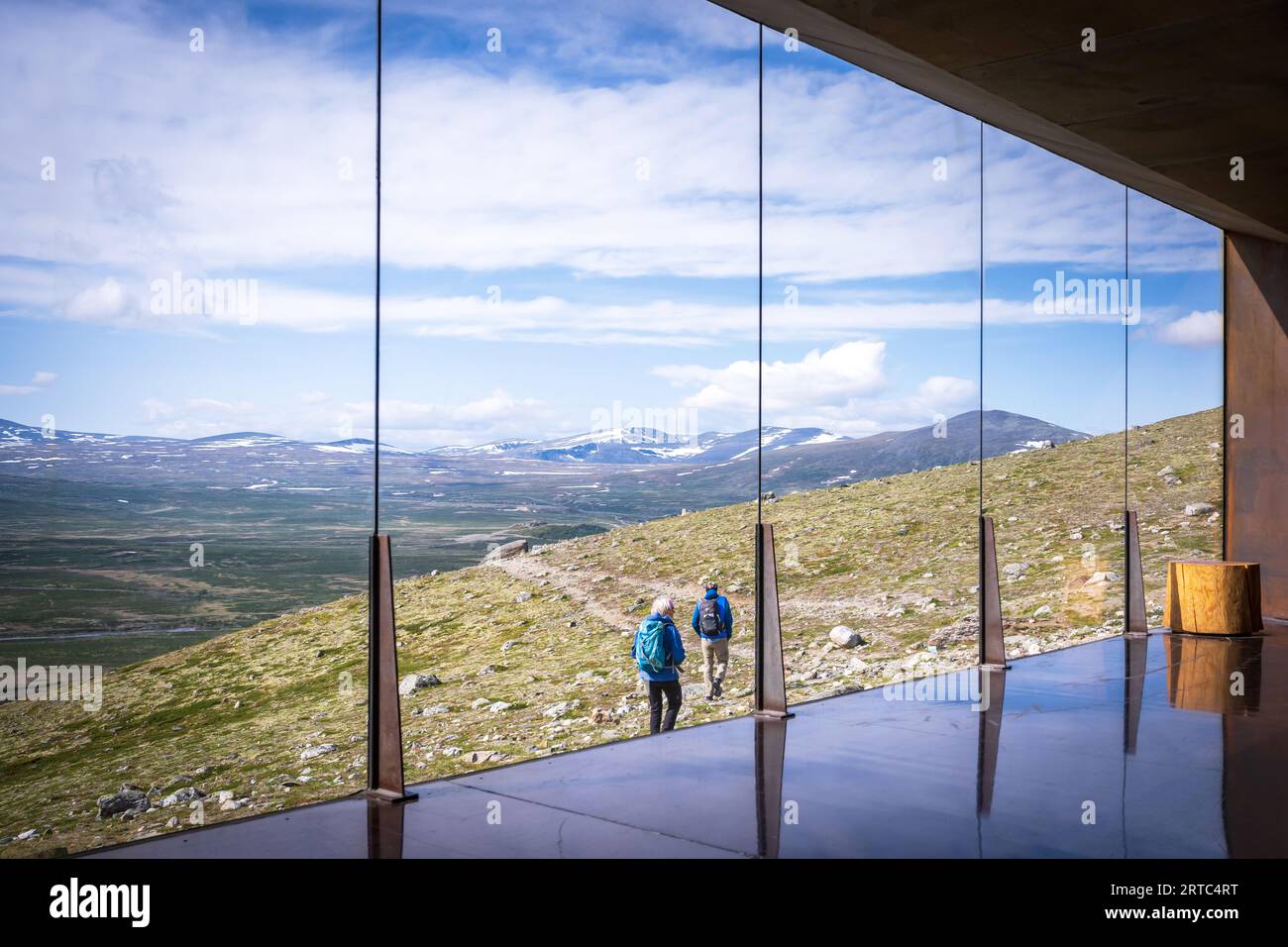 2 hikers in front of the panorama disc of Snoehetta Viewpoint, Hjerkinn ...