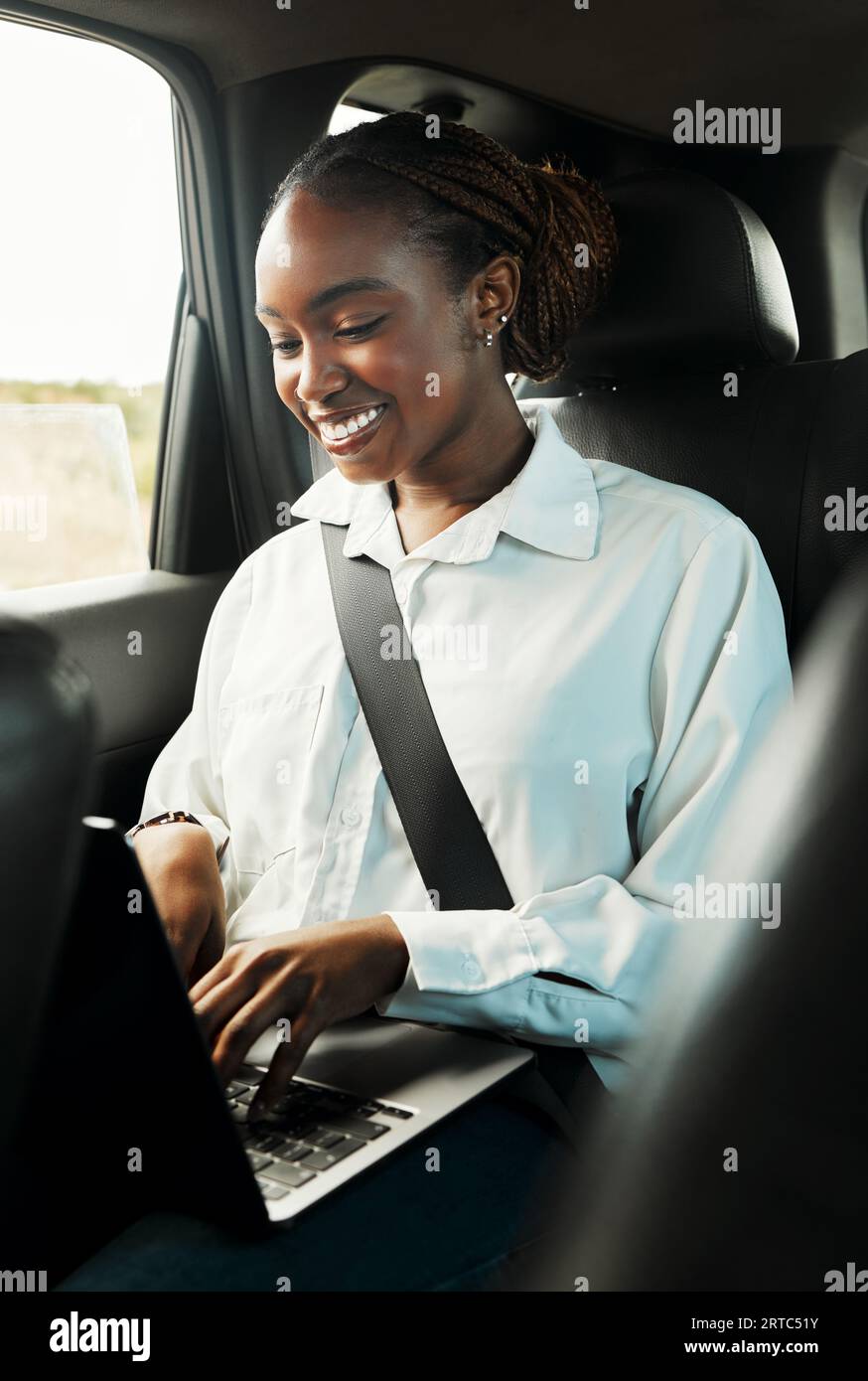 Laptop, smile and black woman typing in car to travel, reading email ...