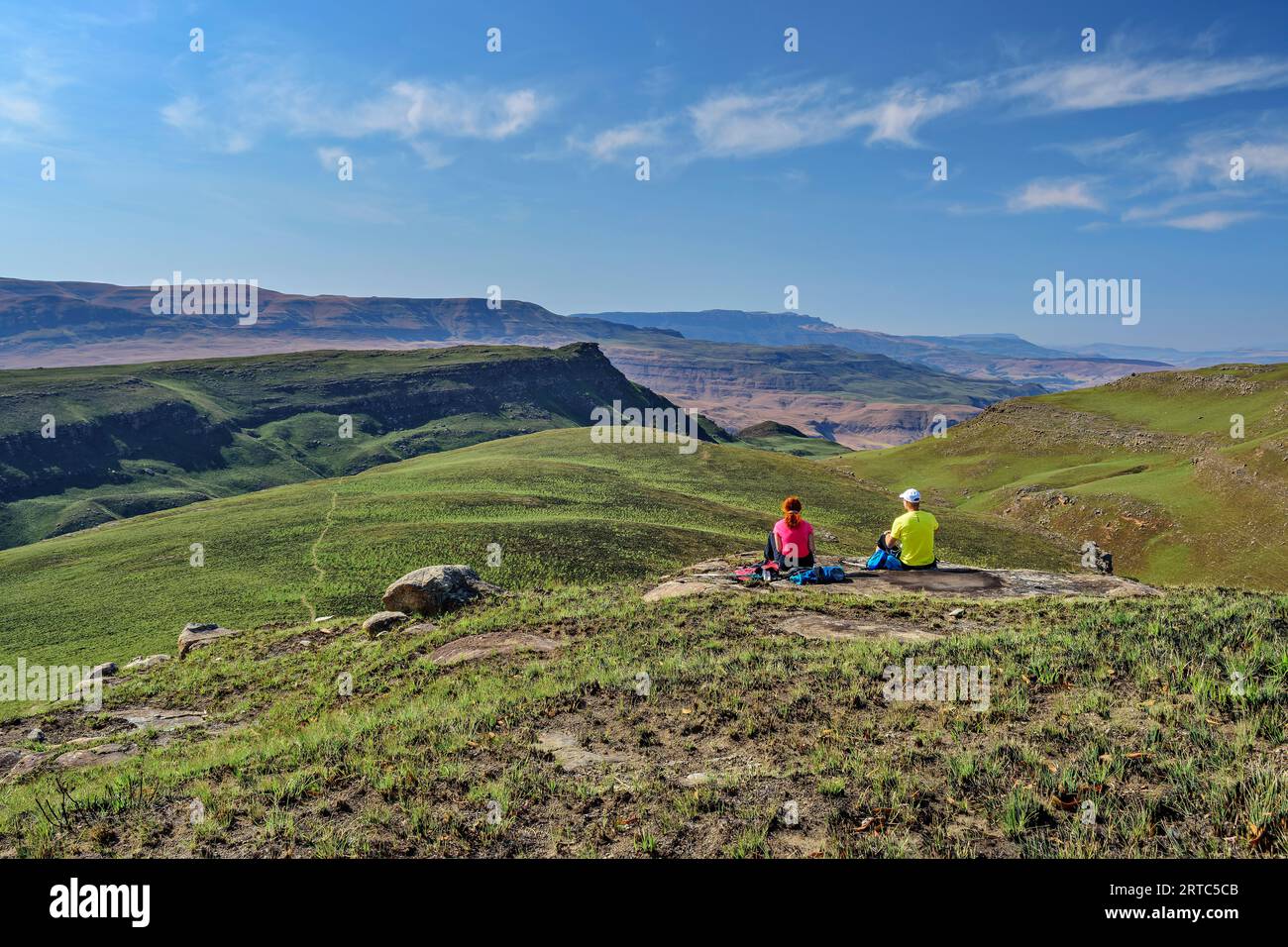 Man and woman hiking sitting on rocks and looking into the Lotheni ...