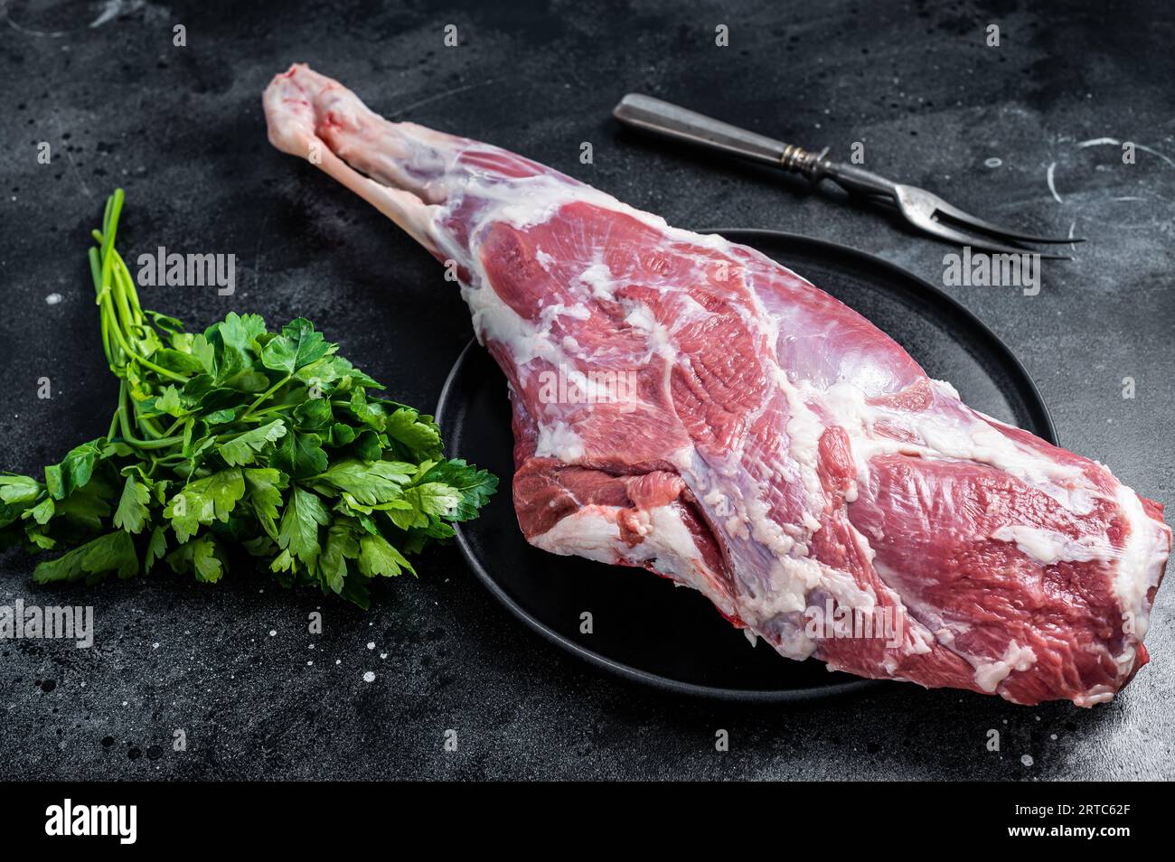 Ready for cooking raw lamb mutton leg with Thigh. Black background. Top ...