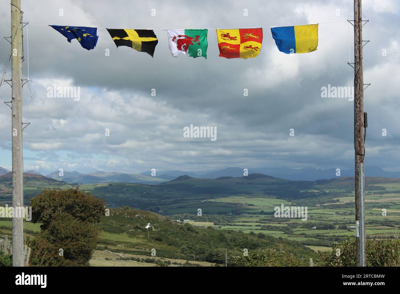 Five flags flying in a line with a view of Snowdonia in the background ...