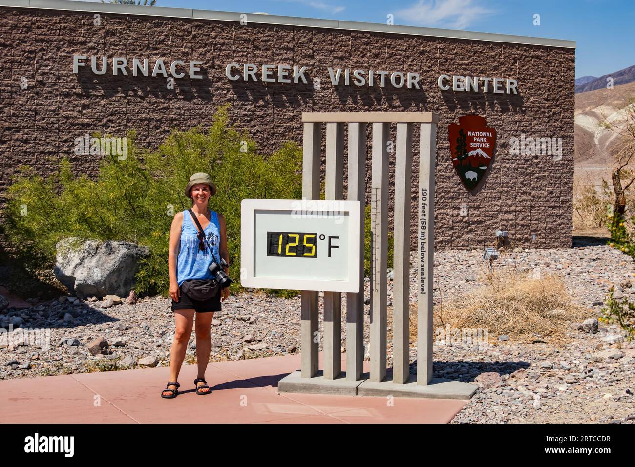 A tourist at the famous thermometer at Furnace Creek in Death Valley at ...