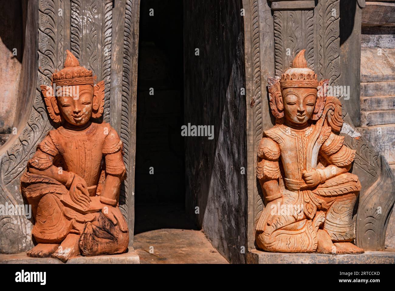 Two ornate Burmese guards sit at the entrance to a pagoda as a tomb in ...